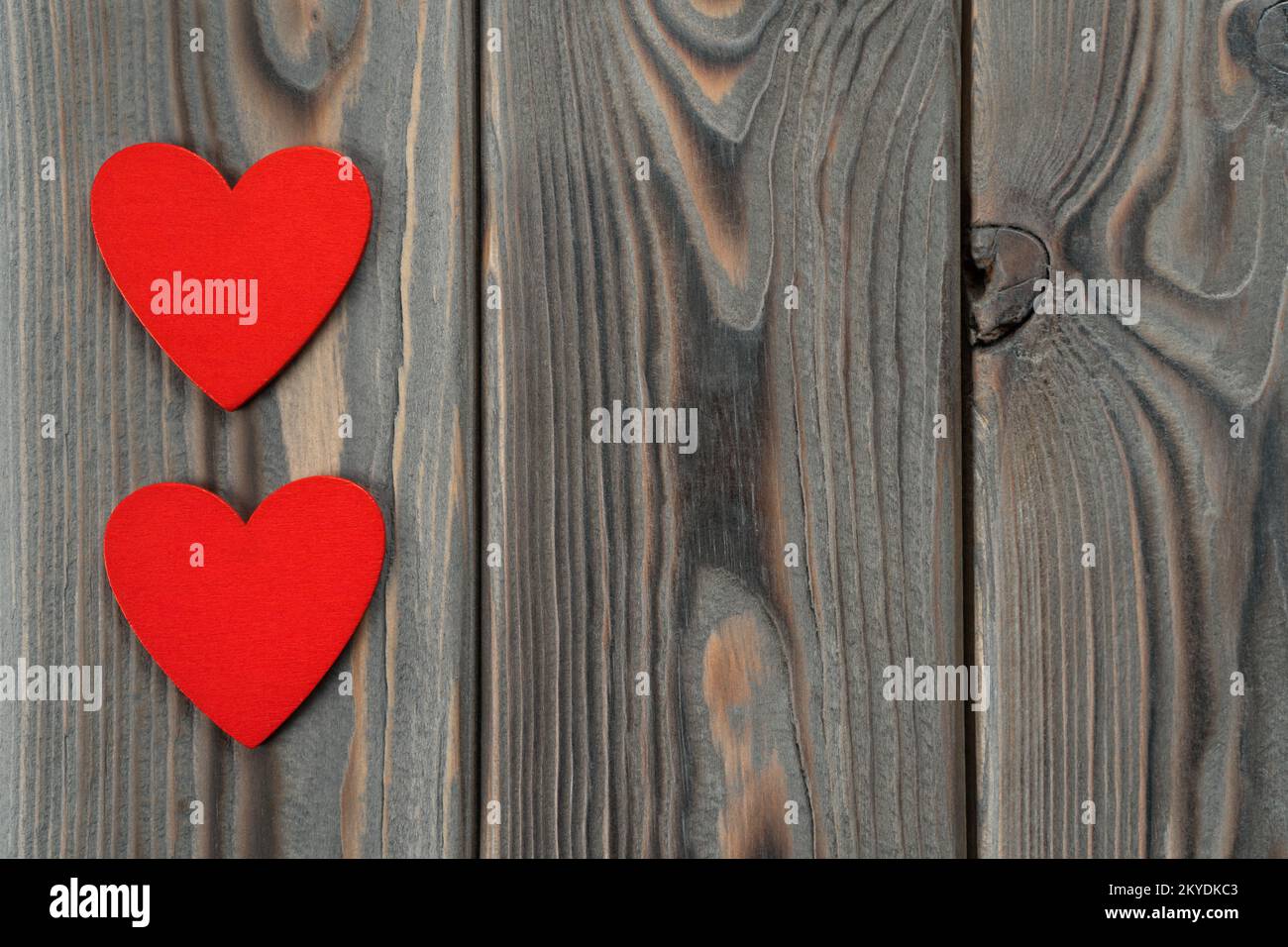 Small red hearts dancing and moving in the circle on dark wood ...