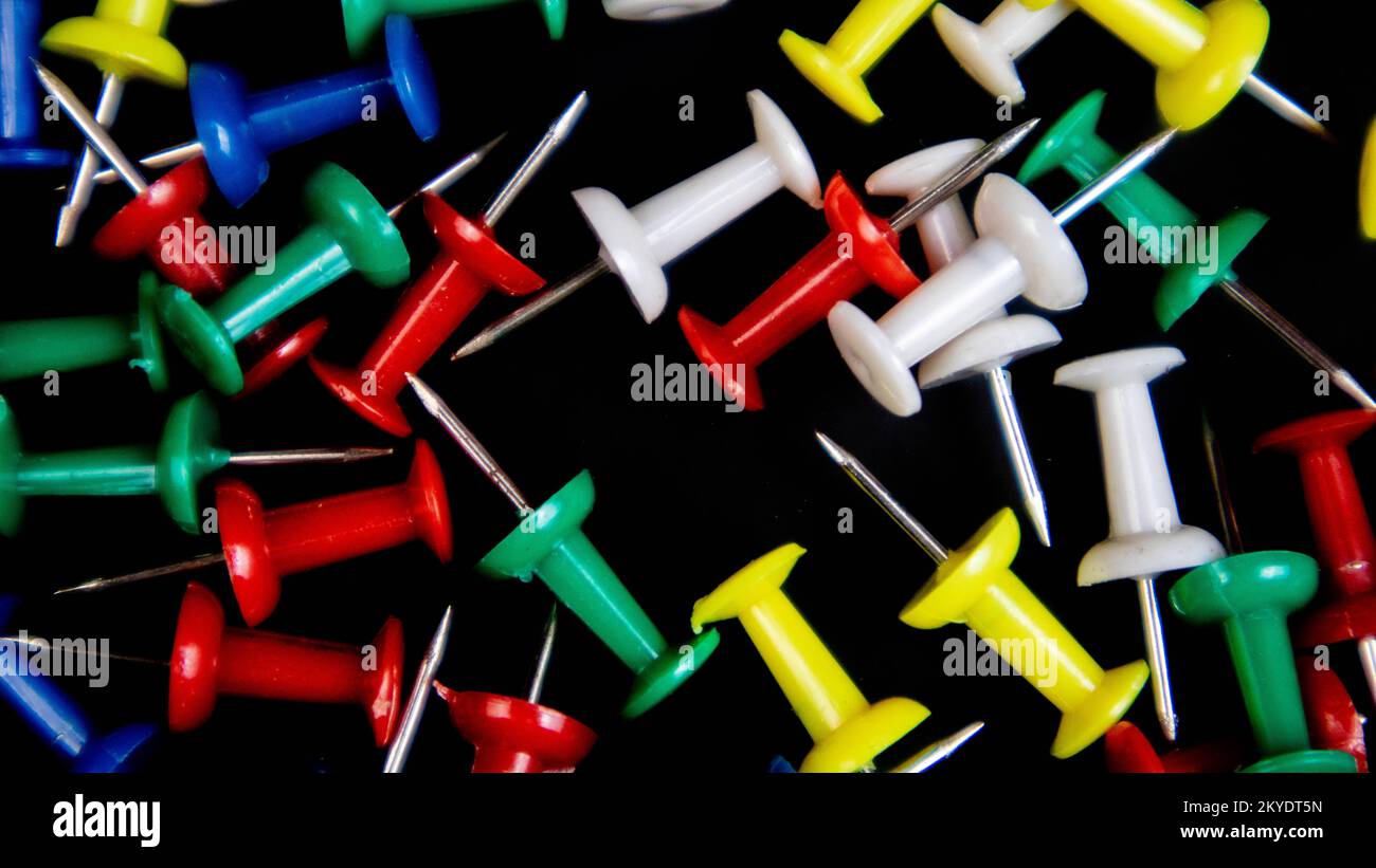 colorful thumbtacks on black background Stock Photo - Alamy