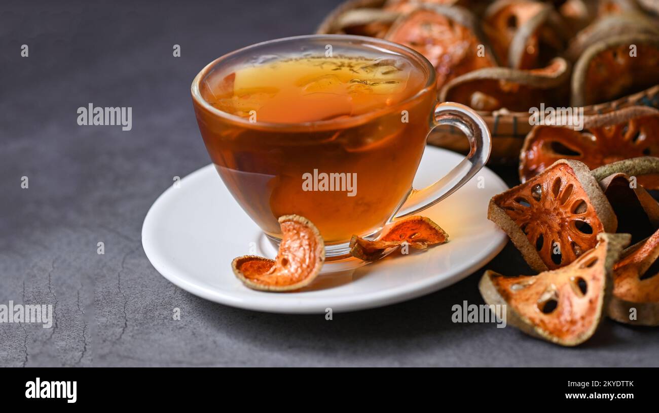 Bael tea on glass with dried bael slices on wooden background, Bael ...