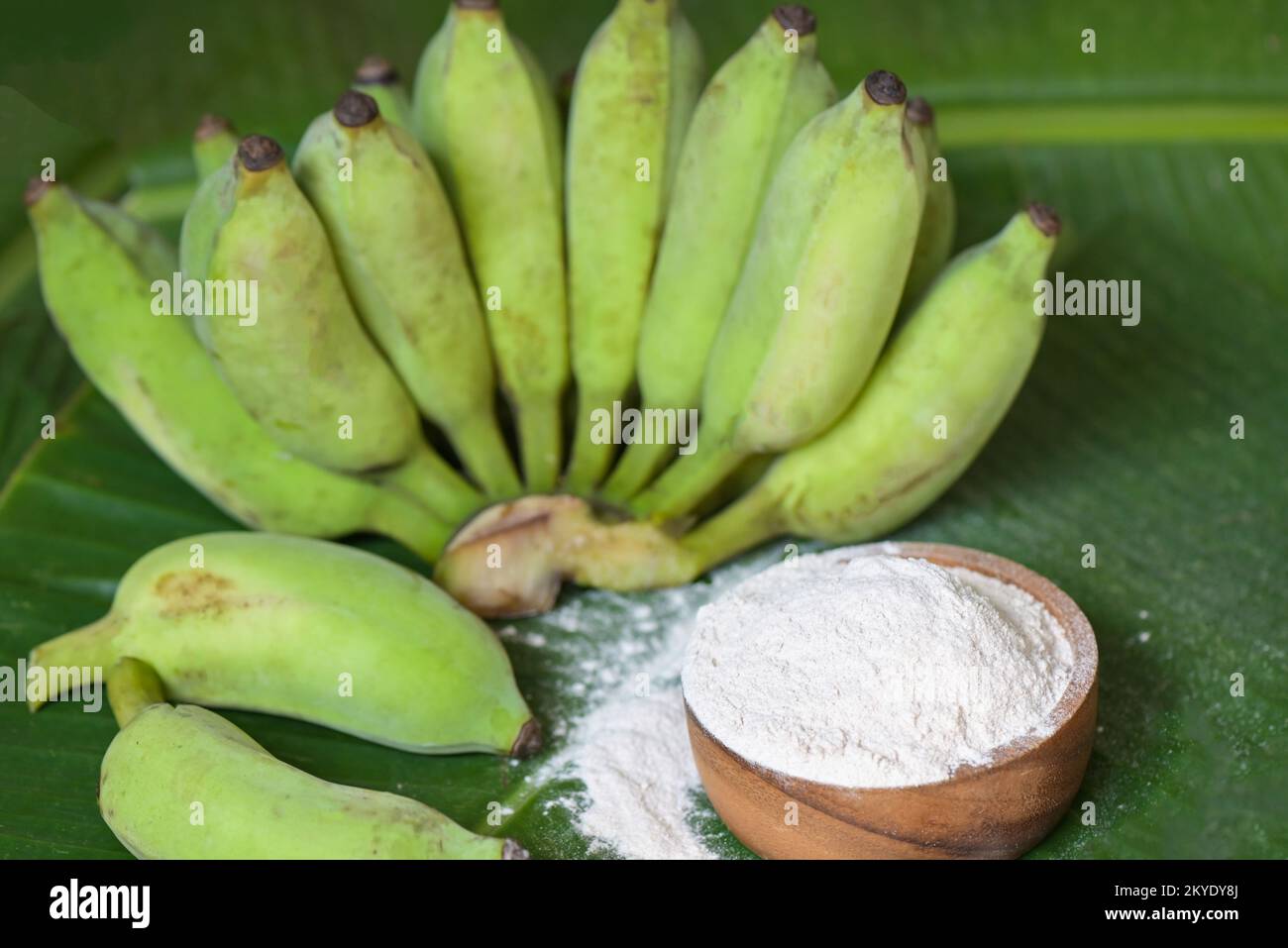banana powder on wooden bowl and raw banana - banana fruit on leaf ...
