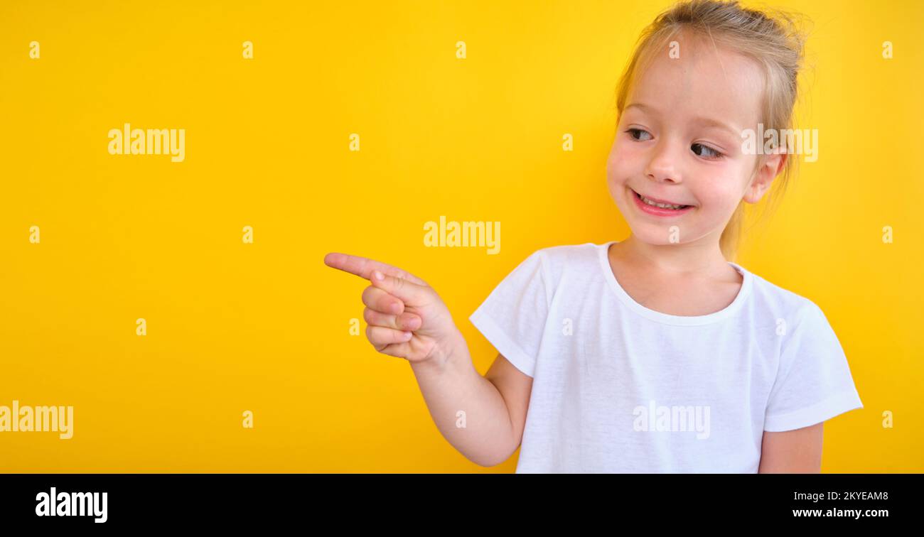 Portrait preschool little girl showing pointing side hand copy space ...