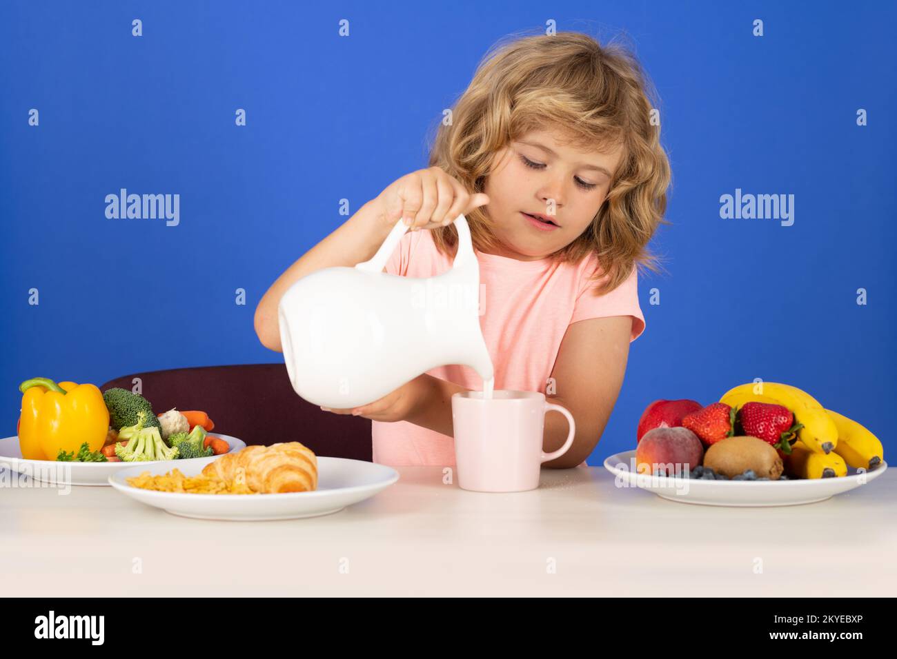 Child pouring milk, studio isolated portrait. Kid boy drink dairy milk ...