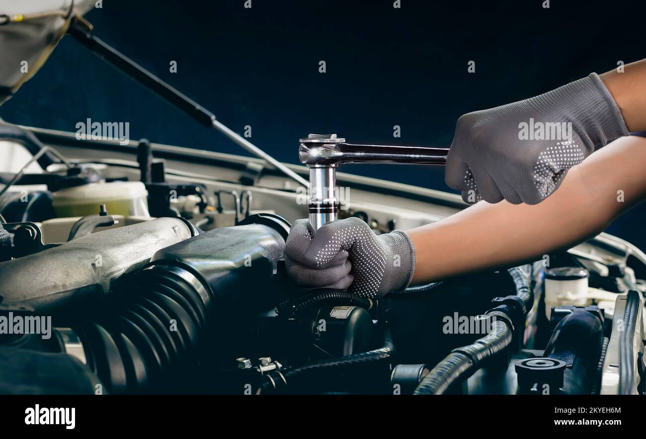 The mechanic works on the engine of the car in the garage, car repair ...