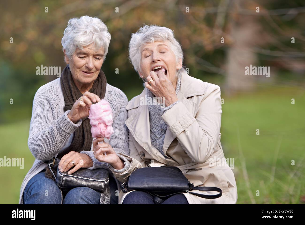 Still our favorite treat. Two senior women eating cotton candy together ...
