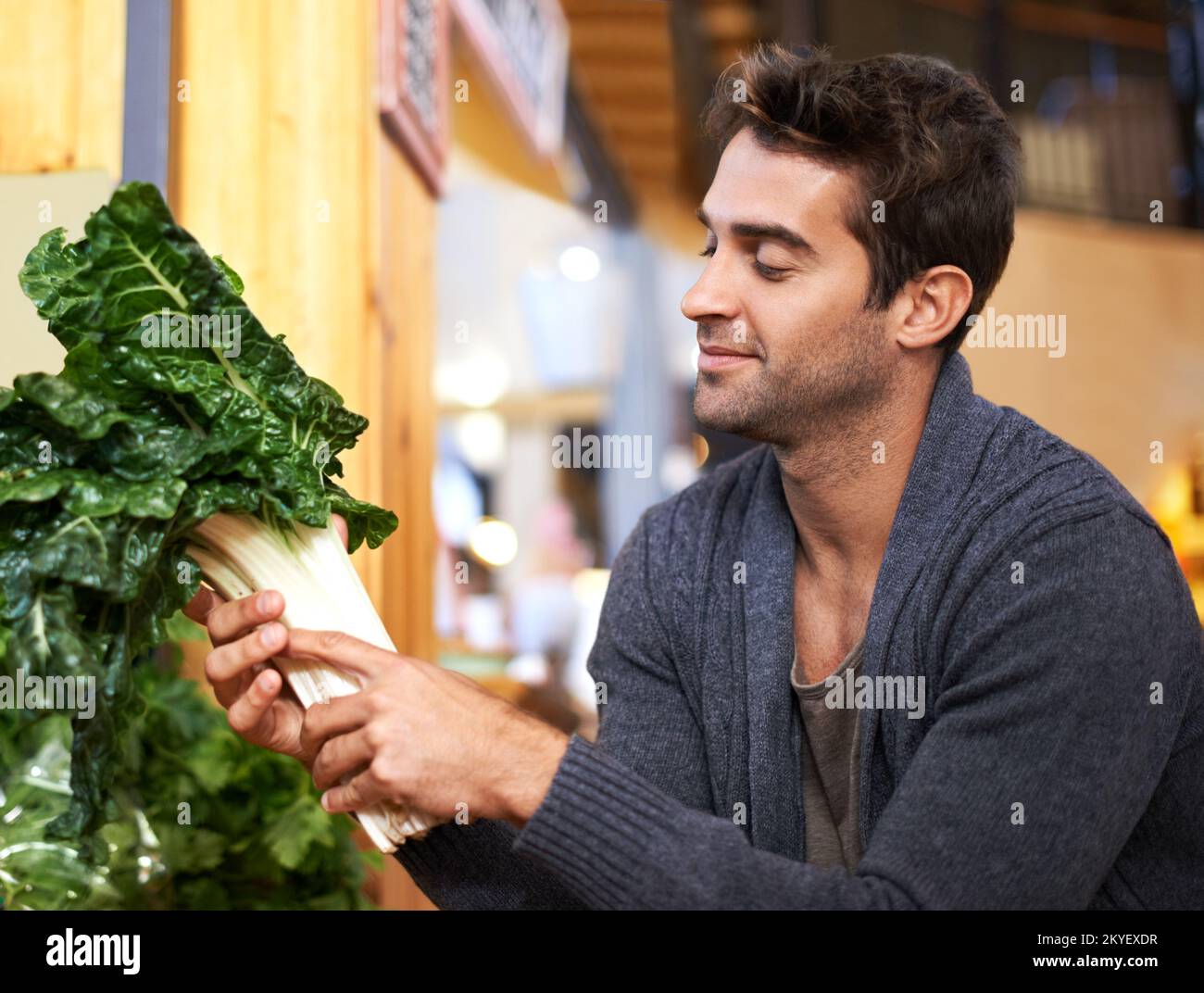 These are excellent. a young man choosing which spinach to buy Stock ...