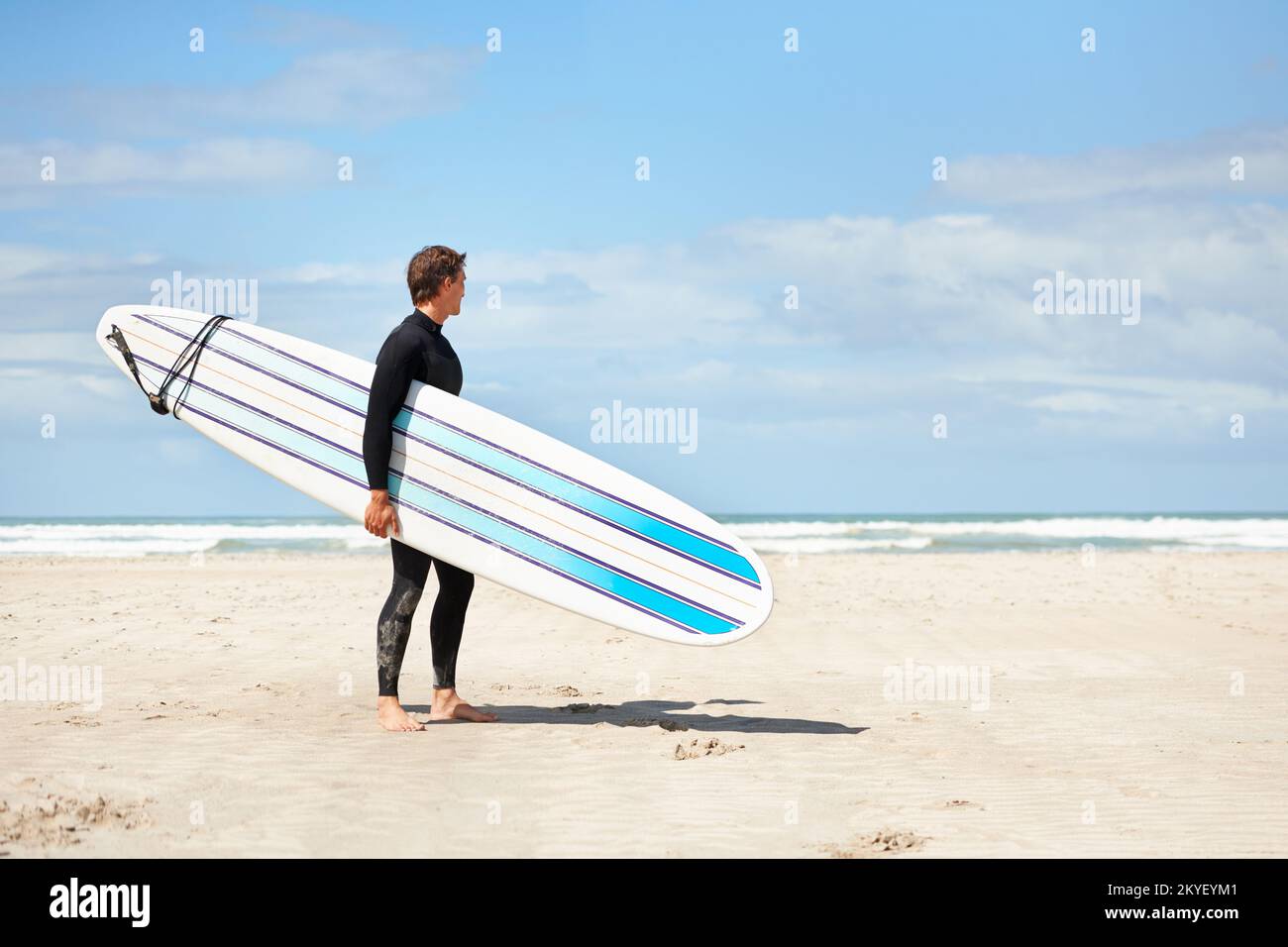 Its just me and my surfboard. a surfer carrying his board while looking ...