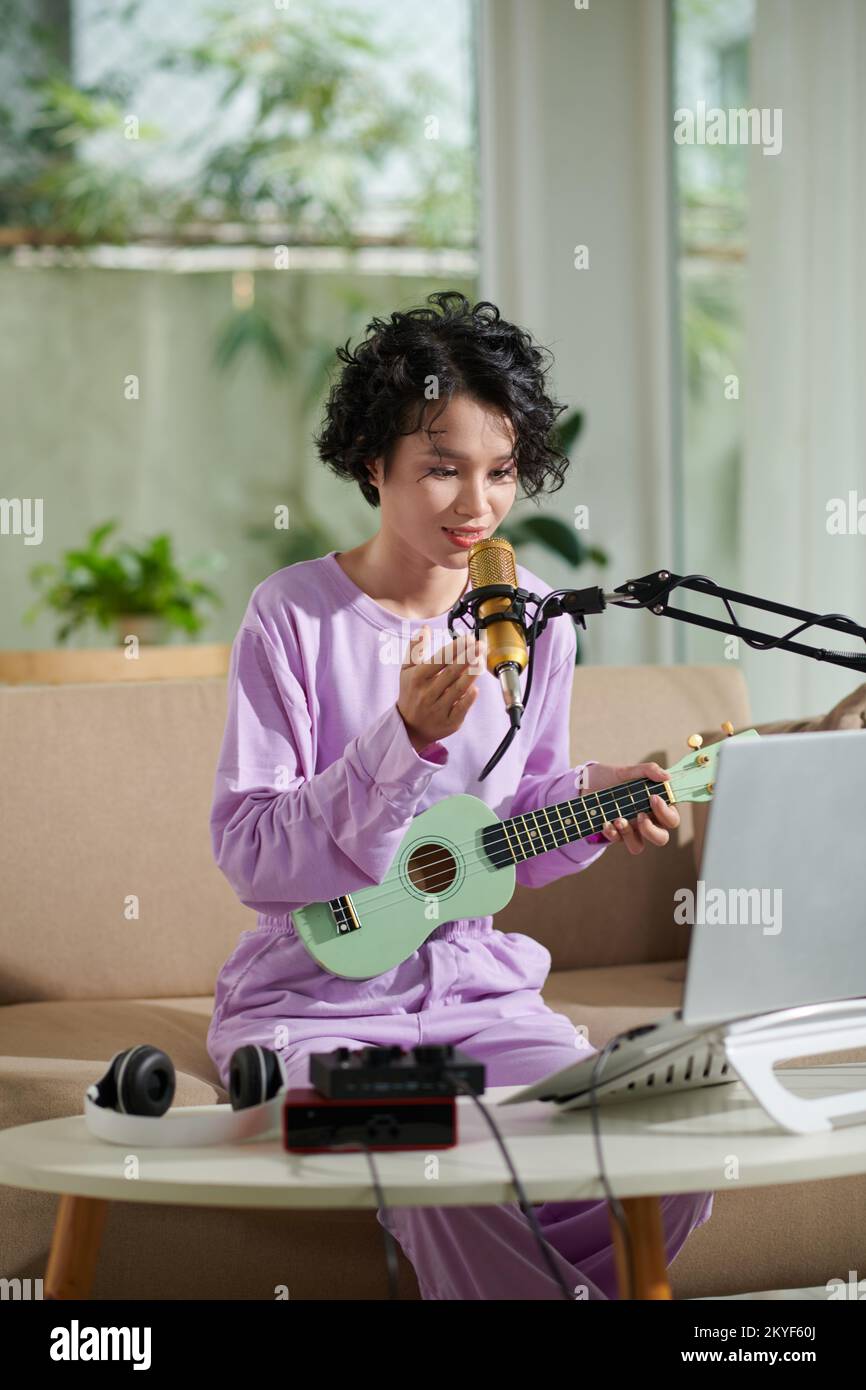 Teenage girl checking mike before streaming herself singing Stock Photo ...