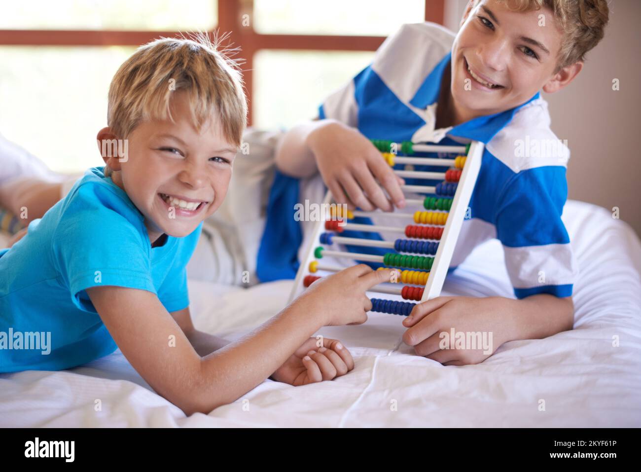 Old-school math. Portrait of two young siblings playing with an abacus ...