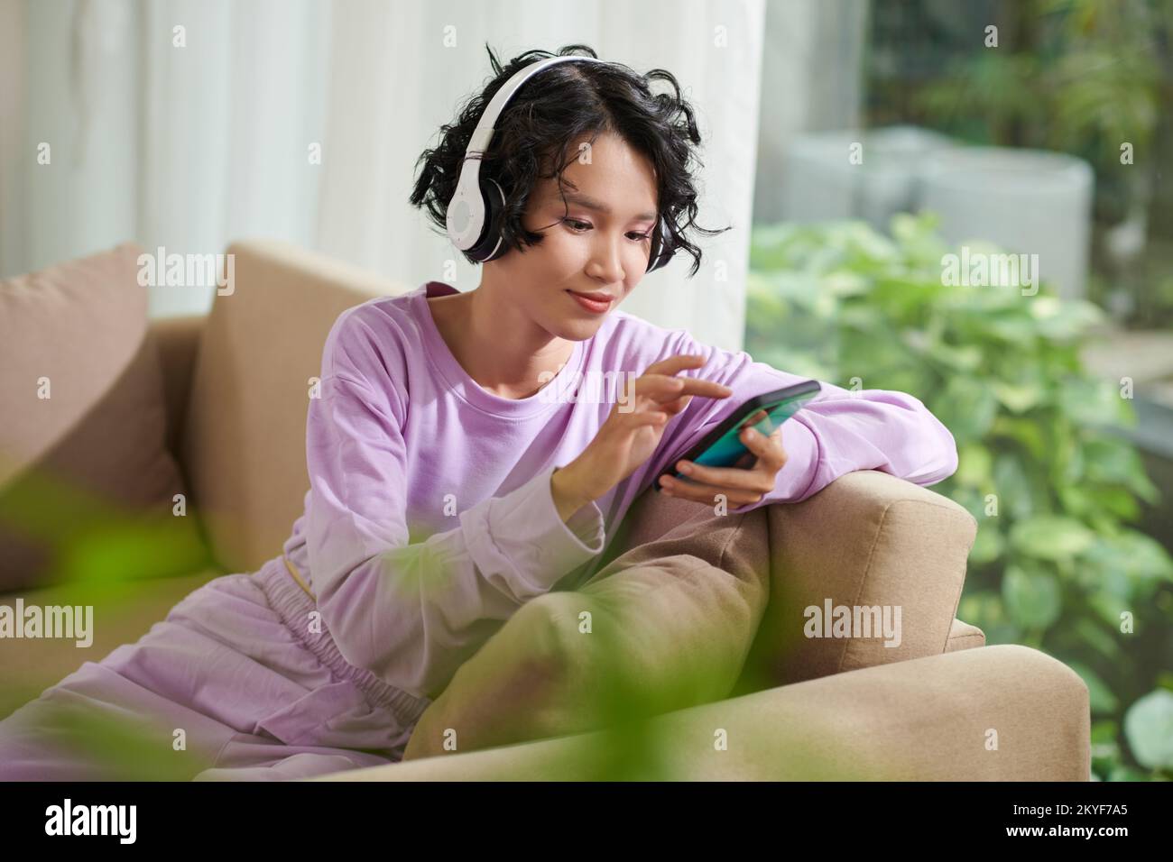 Teenage girl listening to music in headphones and texting friends Stock ...