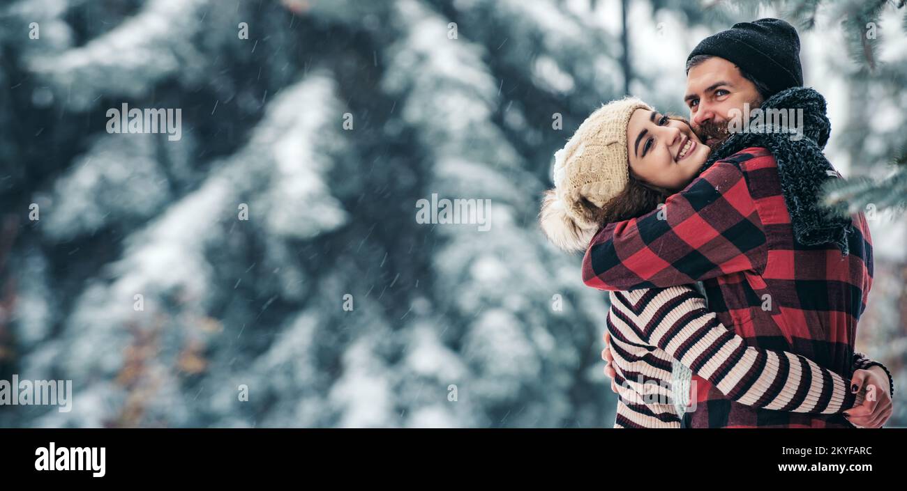 Young couple hug in snow winter background. Couple in love embrace on ...