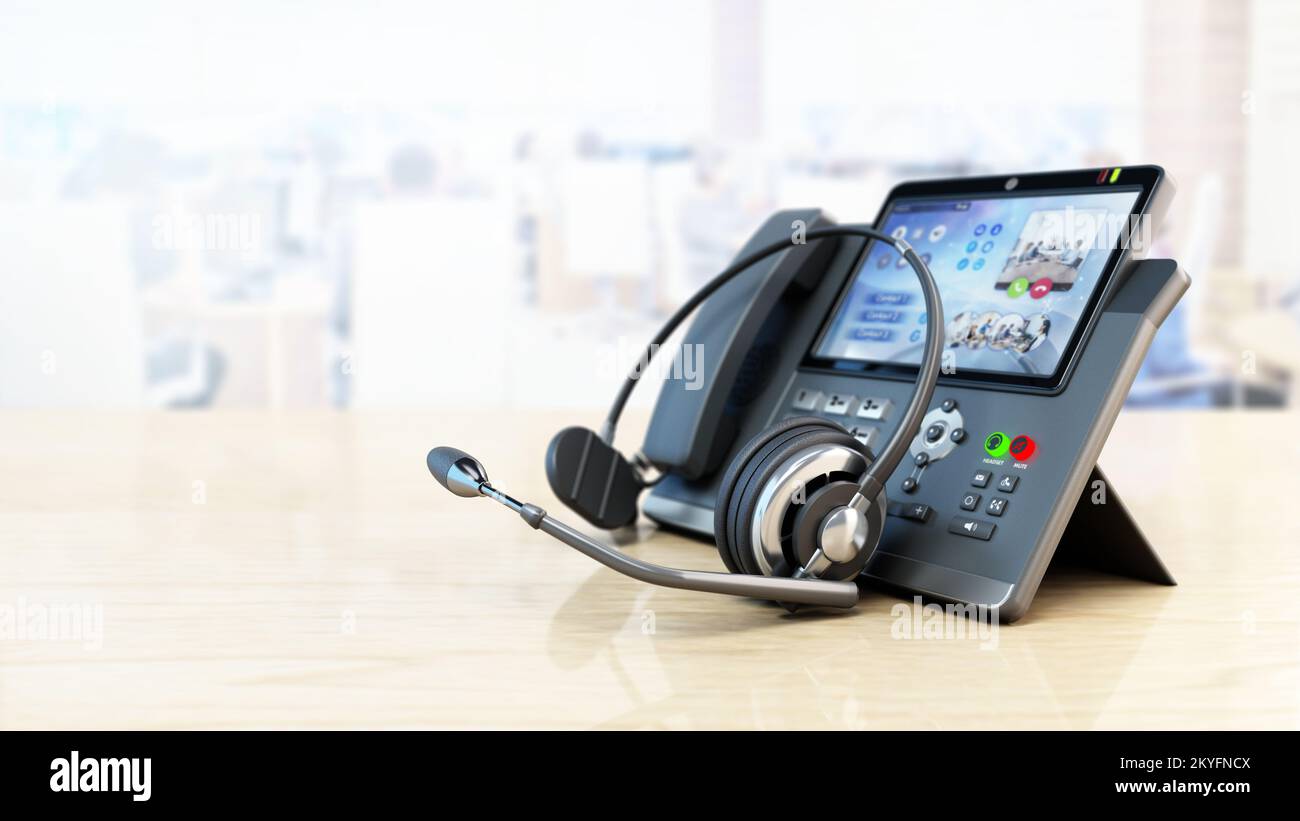 Modern VoIP phone and headset standing on wooden office table. Call ...
