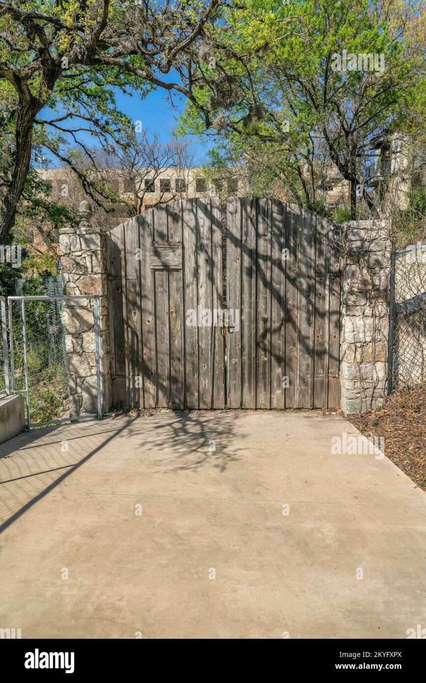 Rustic and old arched wooden gate at the entrance of a private property ...