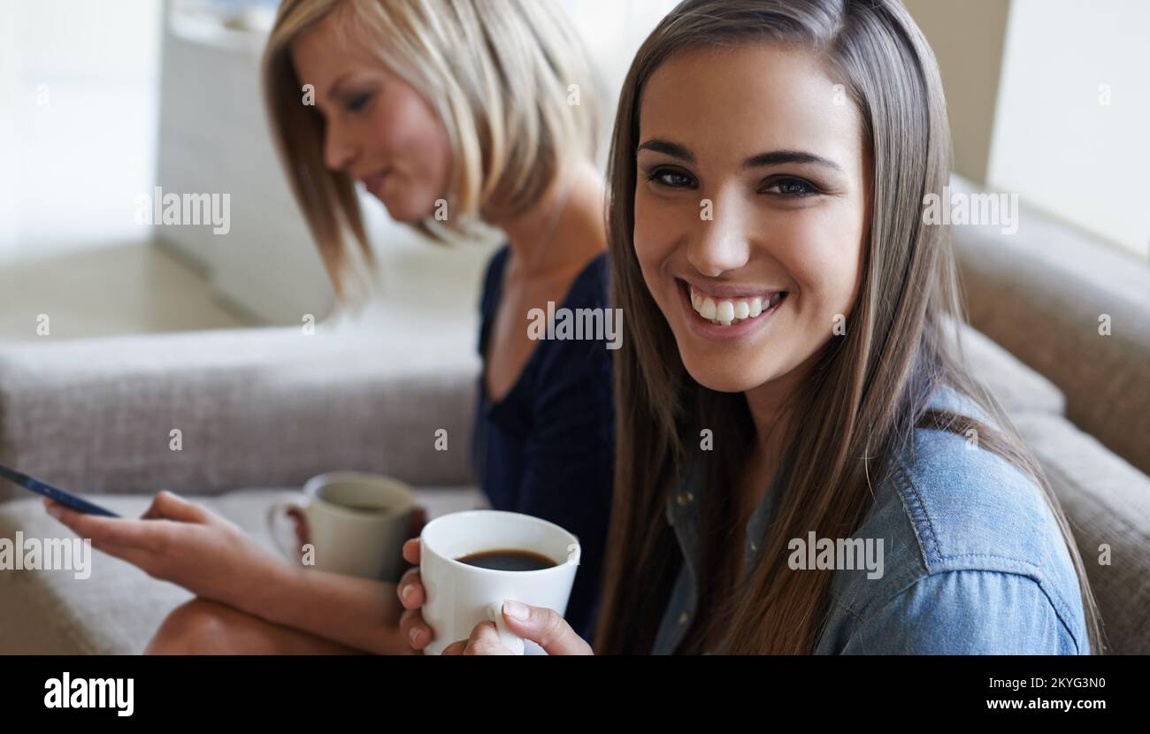 Catching up over a cup of coffee. Two young woman smiling as they drink ...
