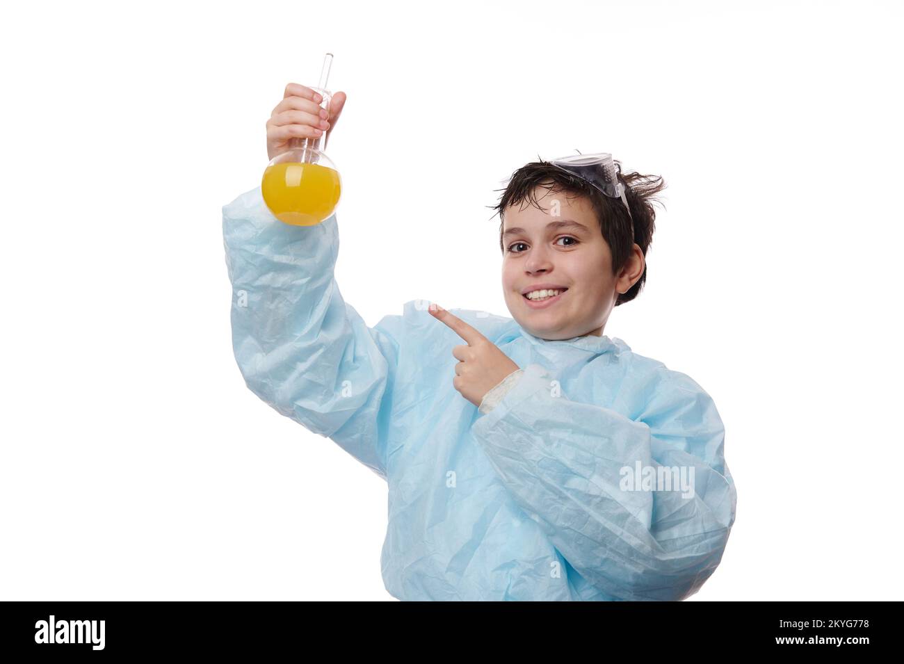 Handsome smart teenage boy in lab coat, pointing with index finger at a ...