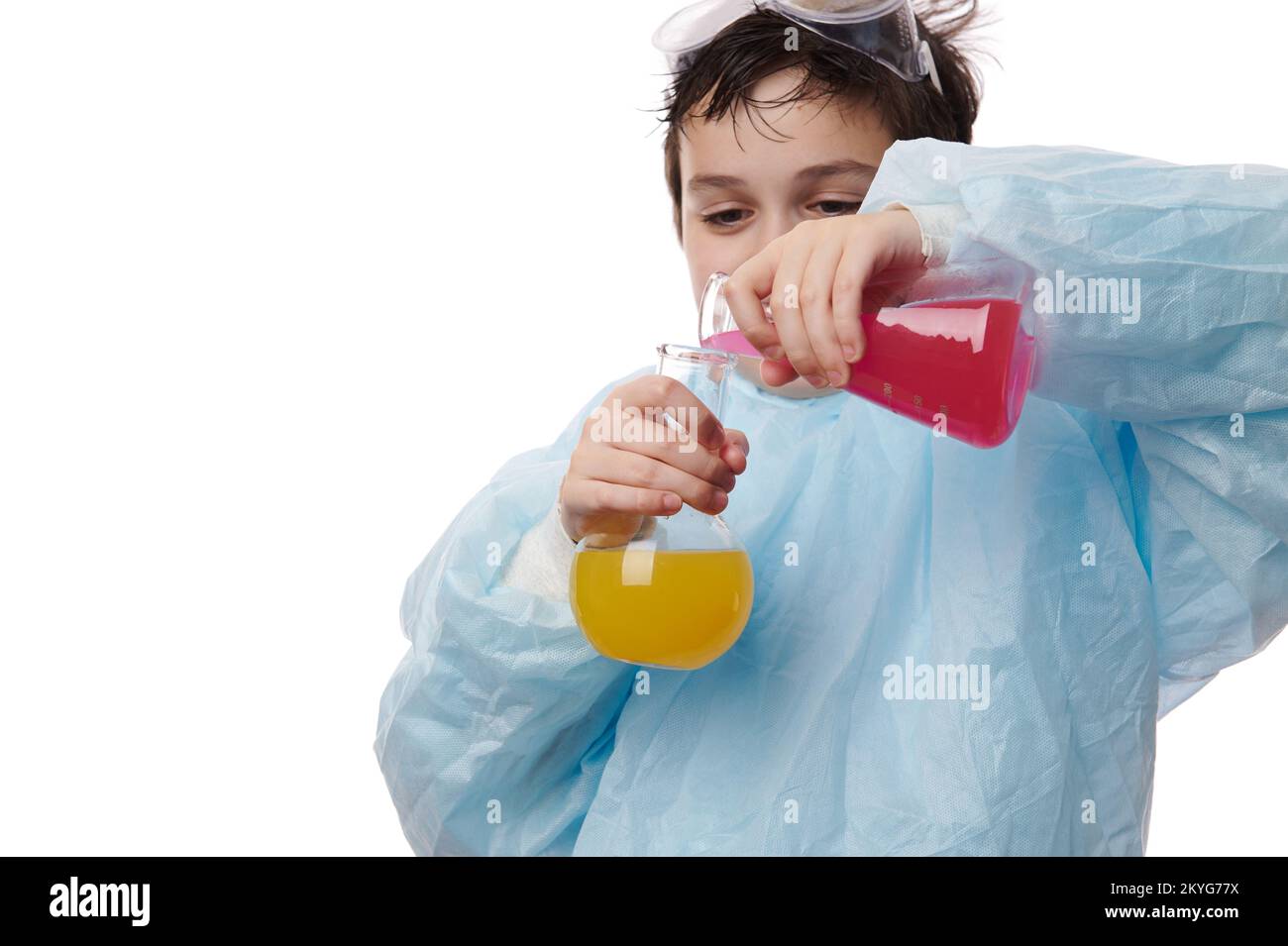 Close-up hands of a schoolboy pouring solution from beaker into a lab ...