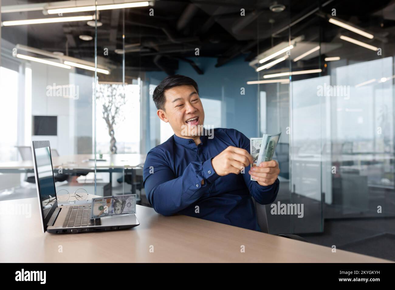 Happy and successful businessman counting money cash inside office ...