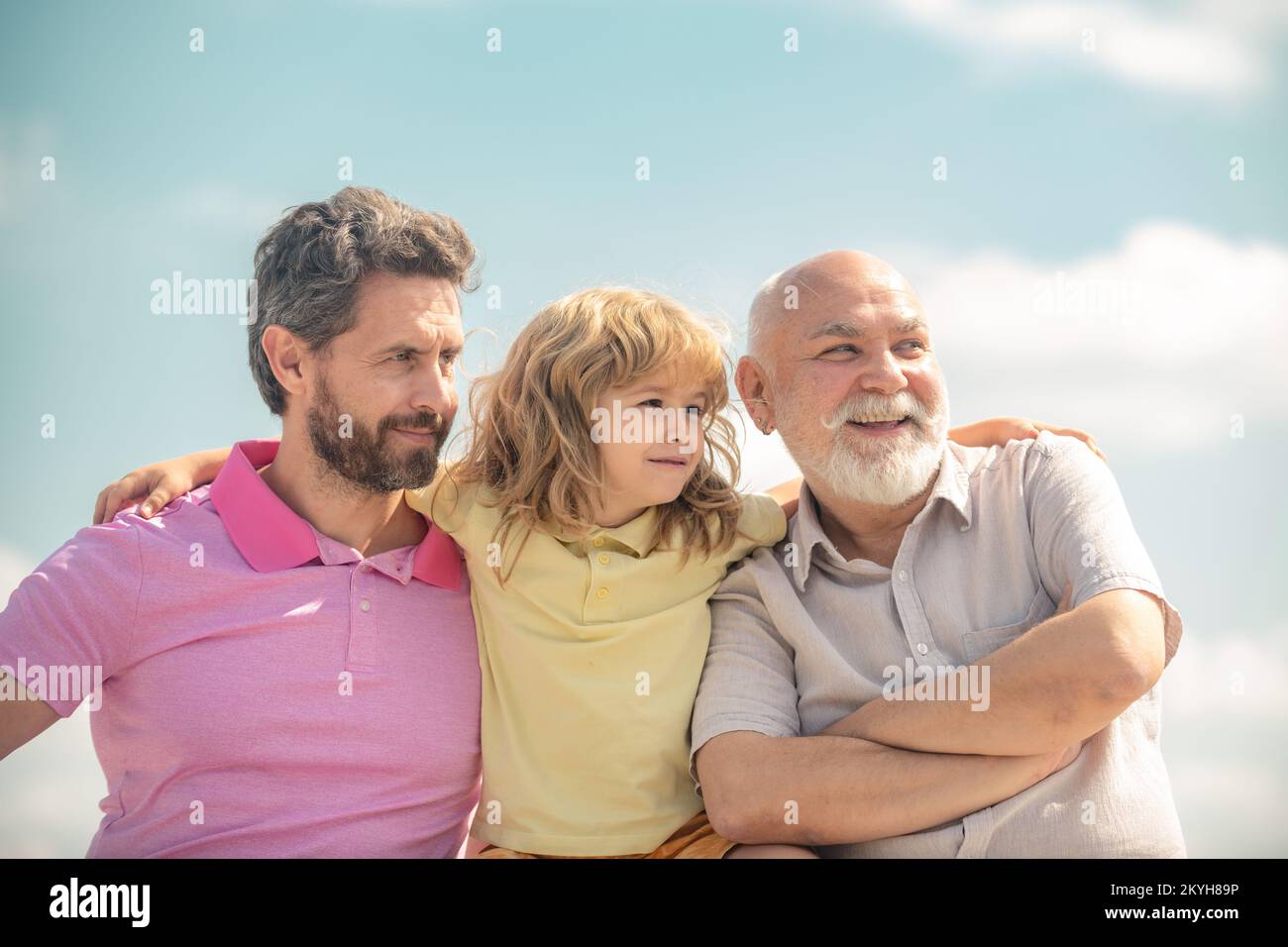 Three generations of men together, portrait of smiling boy, dad and ...