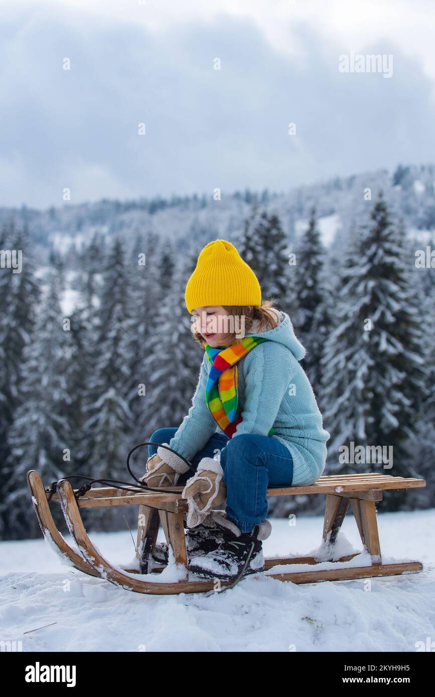 Boy kid enjoying a sleigh ride on winter landscape. Child on sleigh ...
