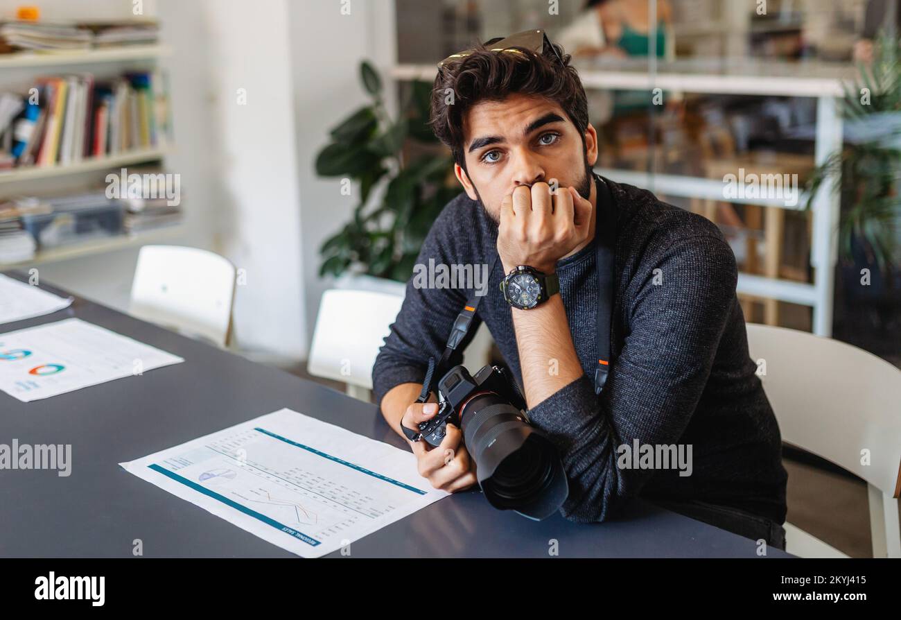 Portrait Of Handsome Male Photographer With Camera In Workplace Stock