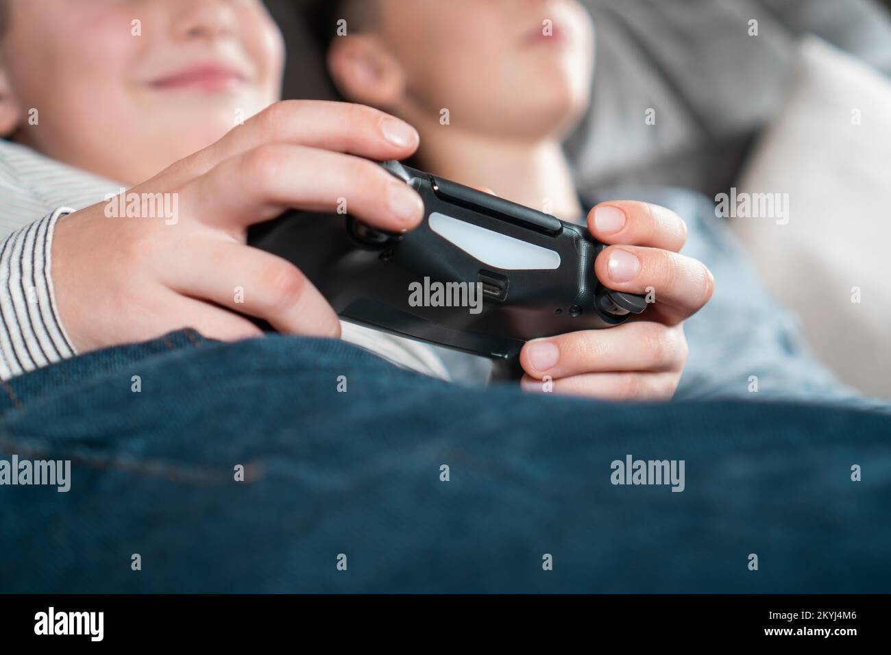 Hands of boy hold modified plastic joystick closeup, selective focus ...