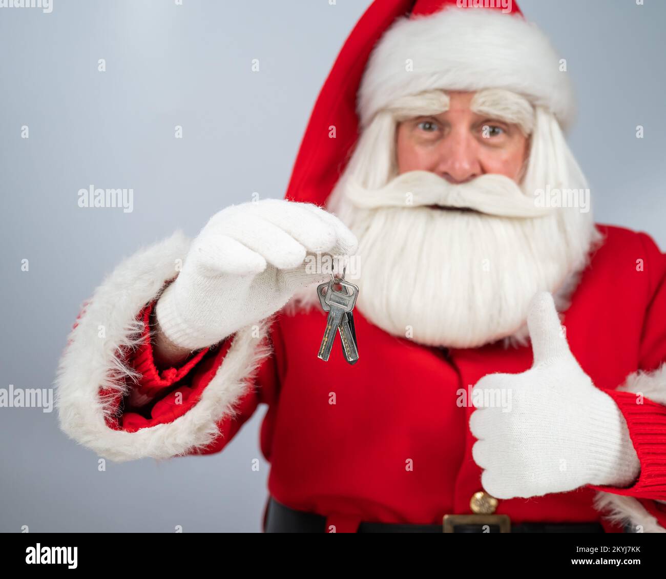 Santa Claus holds keys on a white background and thumb up. New home ...