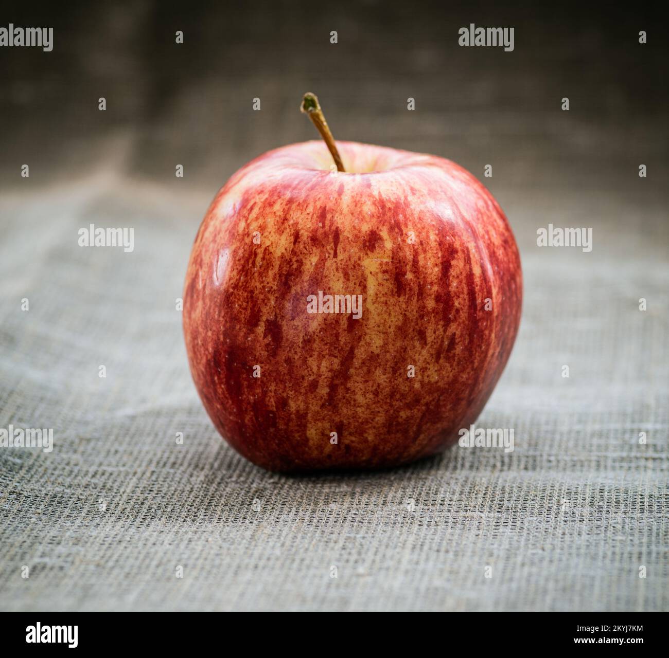 Fresh red apple on sackcloth. Selective focus Stock Photo - Alamy