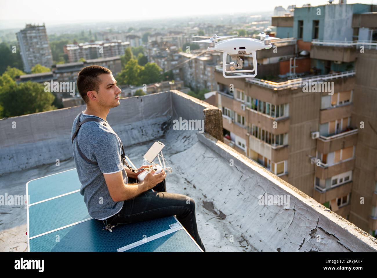 Young technician man flying UAV drone with remote control in city Stock ...