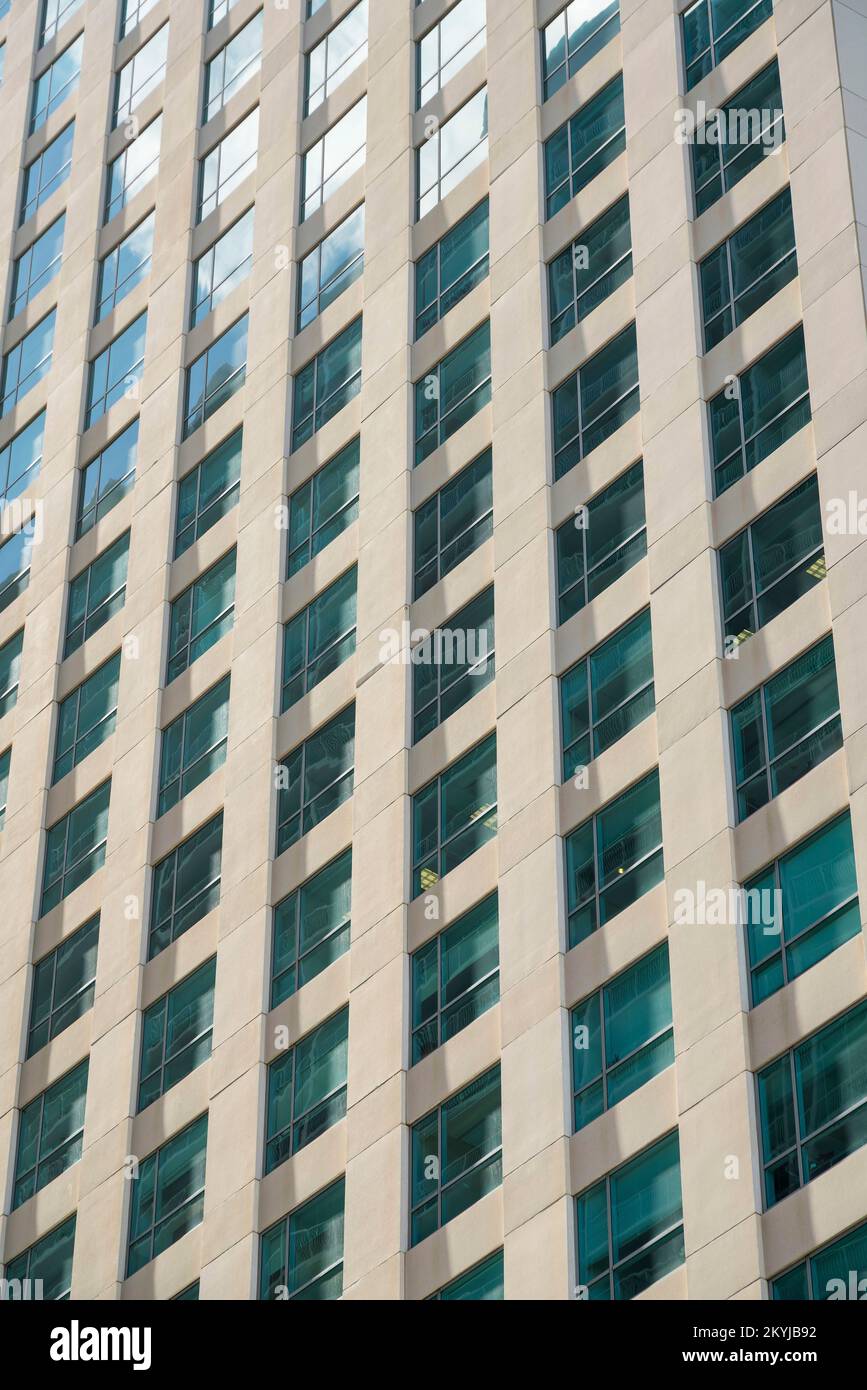 Grid multi-storey building close-up with clear reflective glass windows ...