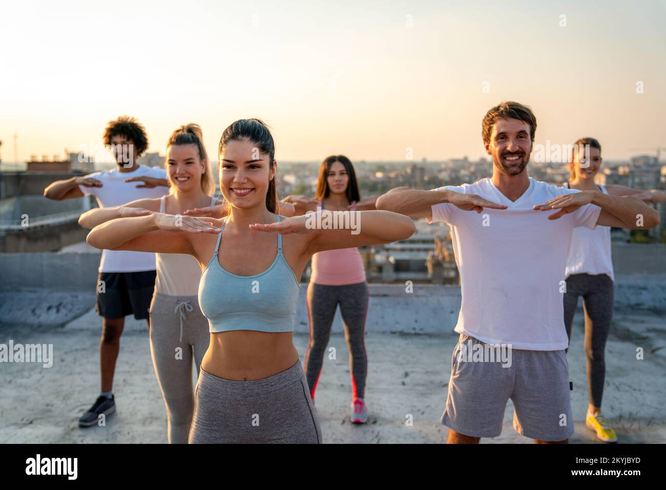 Group of happy fit people friends exercising together outdoor to stay ...