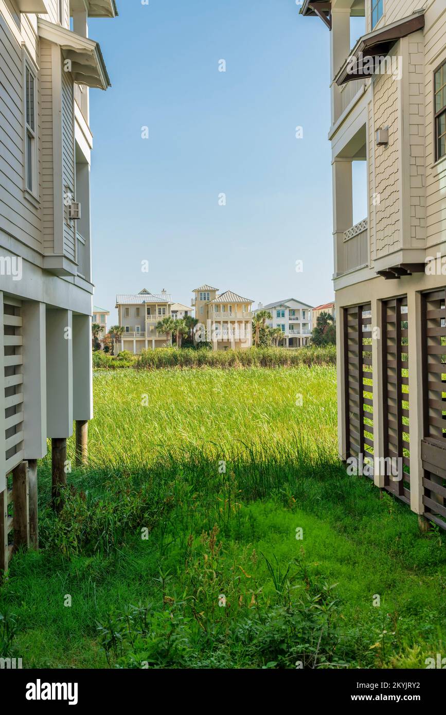 View of three-storey houses and grass field from the side of two ...