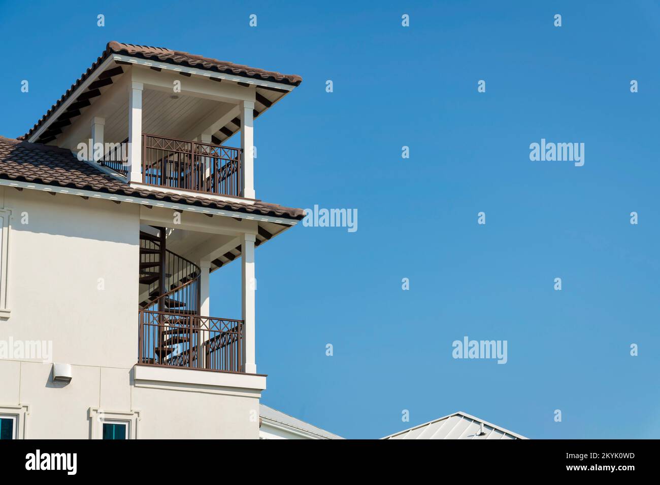 Side view of a residential building with white wall and brown roof ...