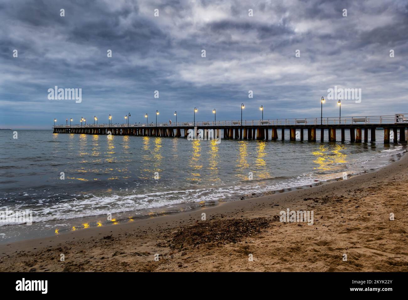 Beach and pier on the Baltic Sea at overcast dawn in Gdynia Orlowo ...