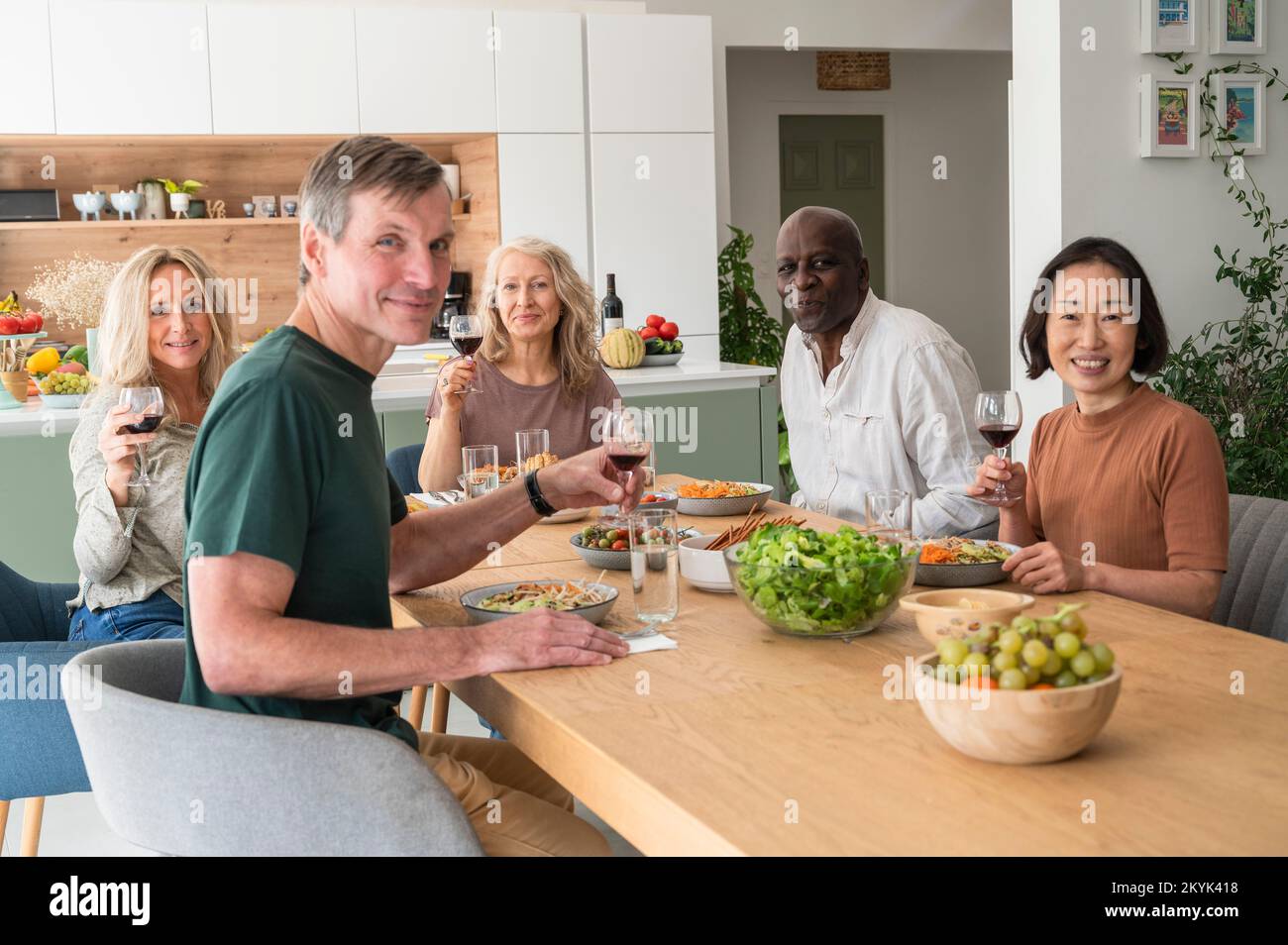 Group of diverse senior friends gathered together for lunch in the ...
