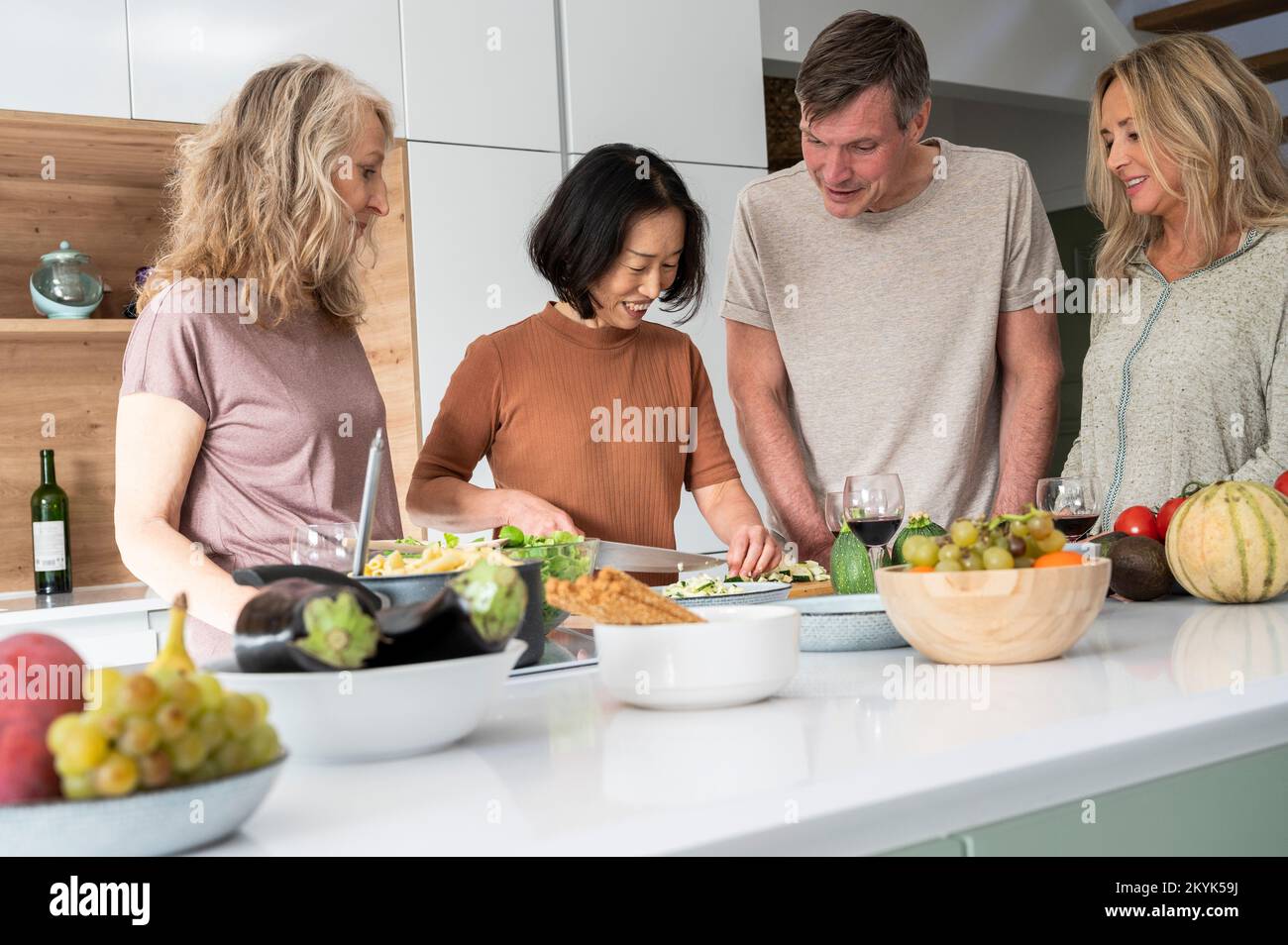 Group of senior friends watching how to cook a meal while gathered ...