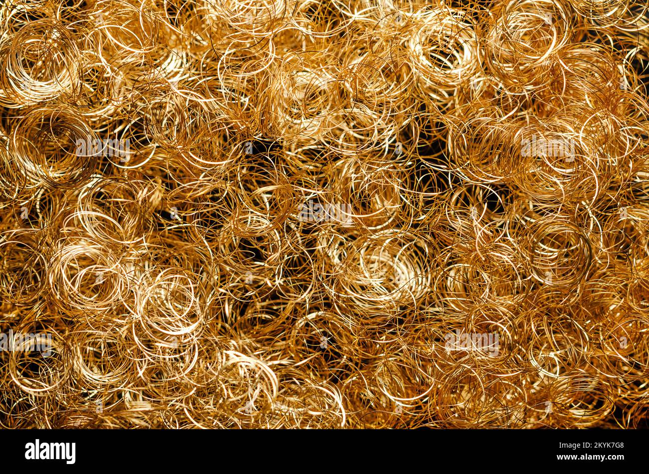 Golden metallic angel hair, background, from above. Curly gold lametta ...