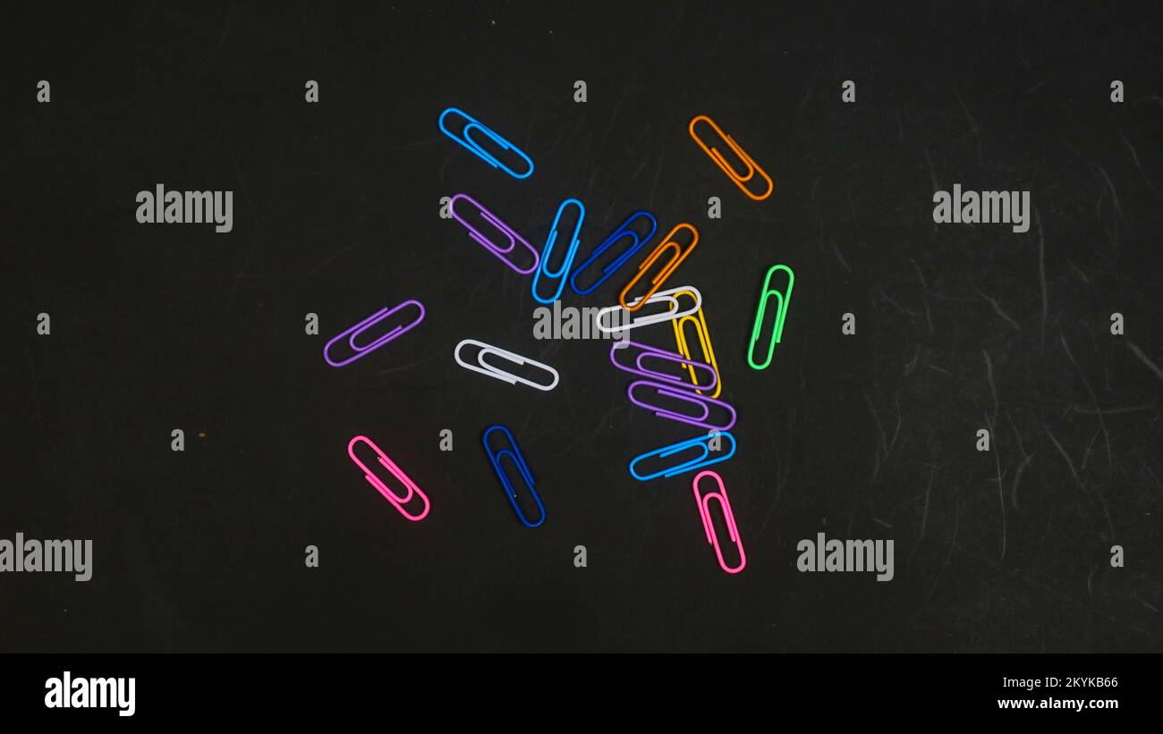 Colorful paper clips isolated on black background Stock Photo - Alamy