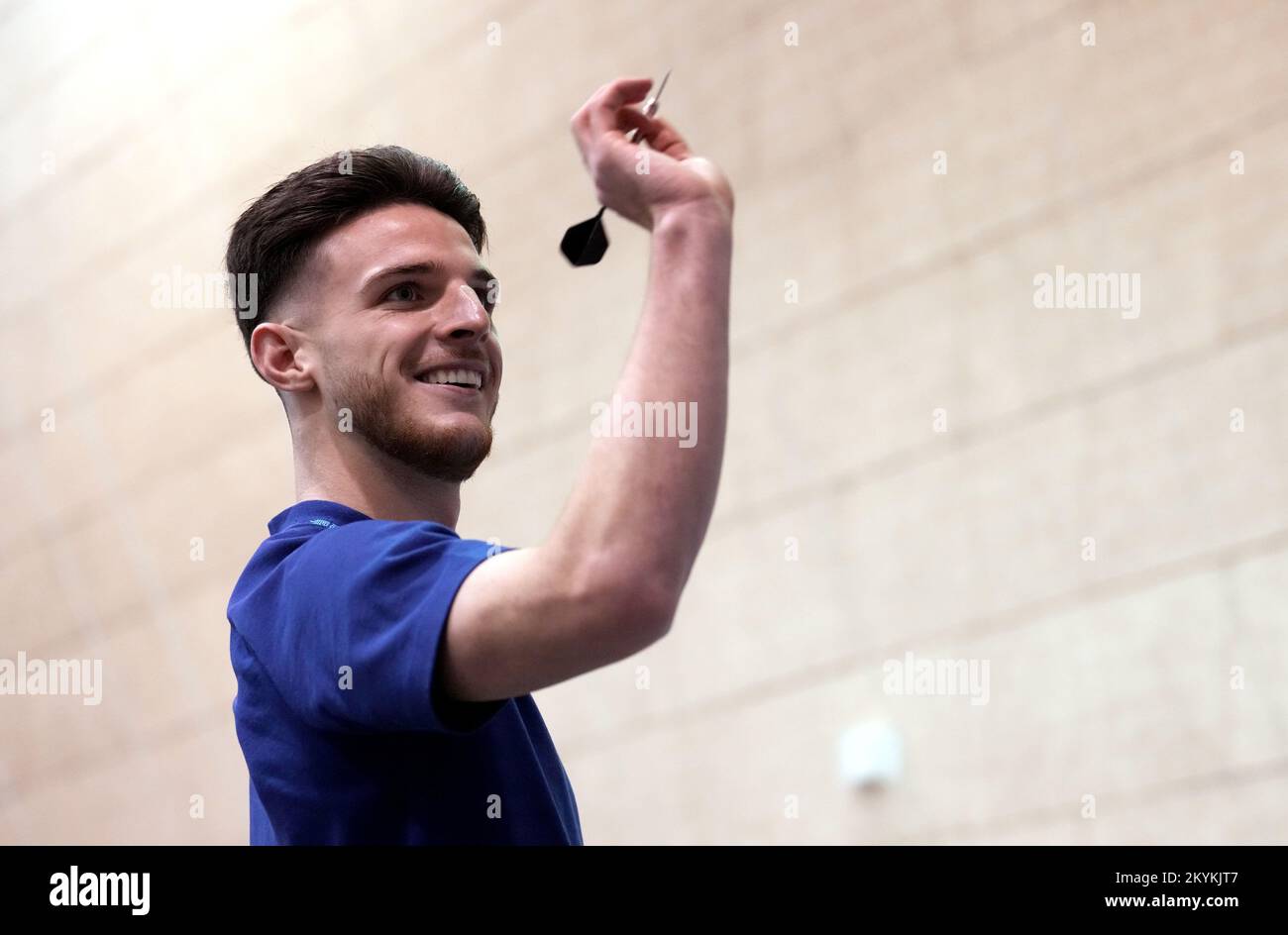 England's Declan Rice throws a dart during a game against a member of ...
