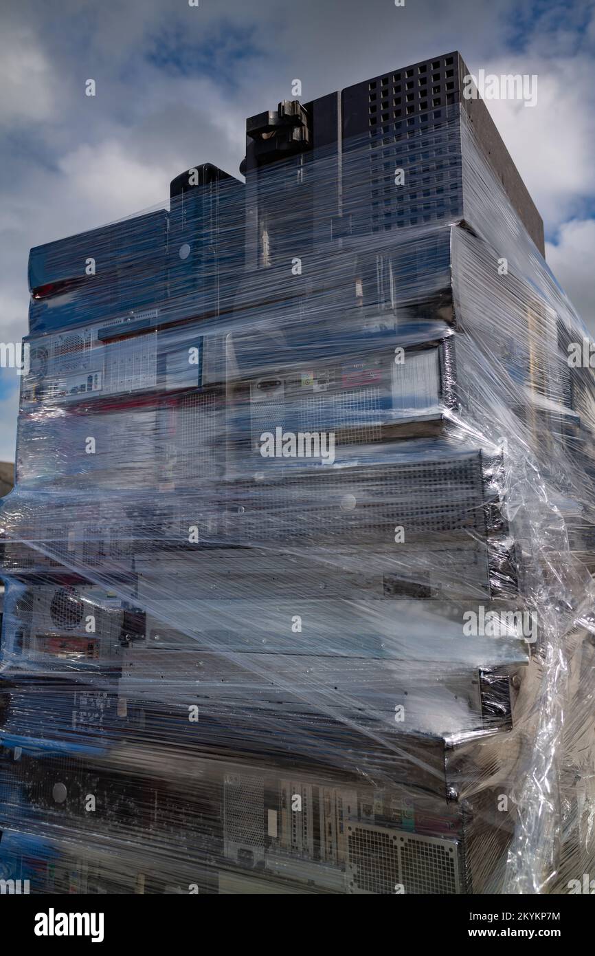 Pile of old broken computer desktop towers wrapped up on a pallet at an ...