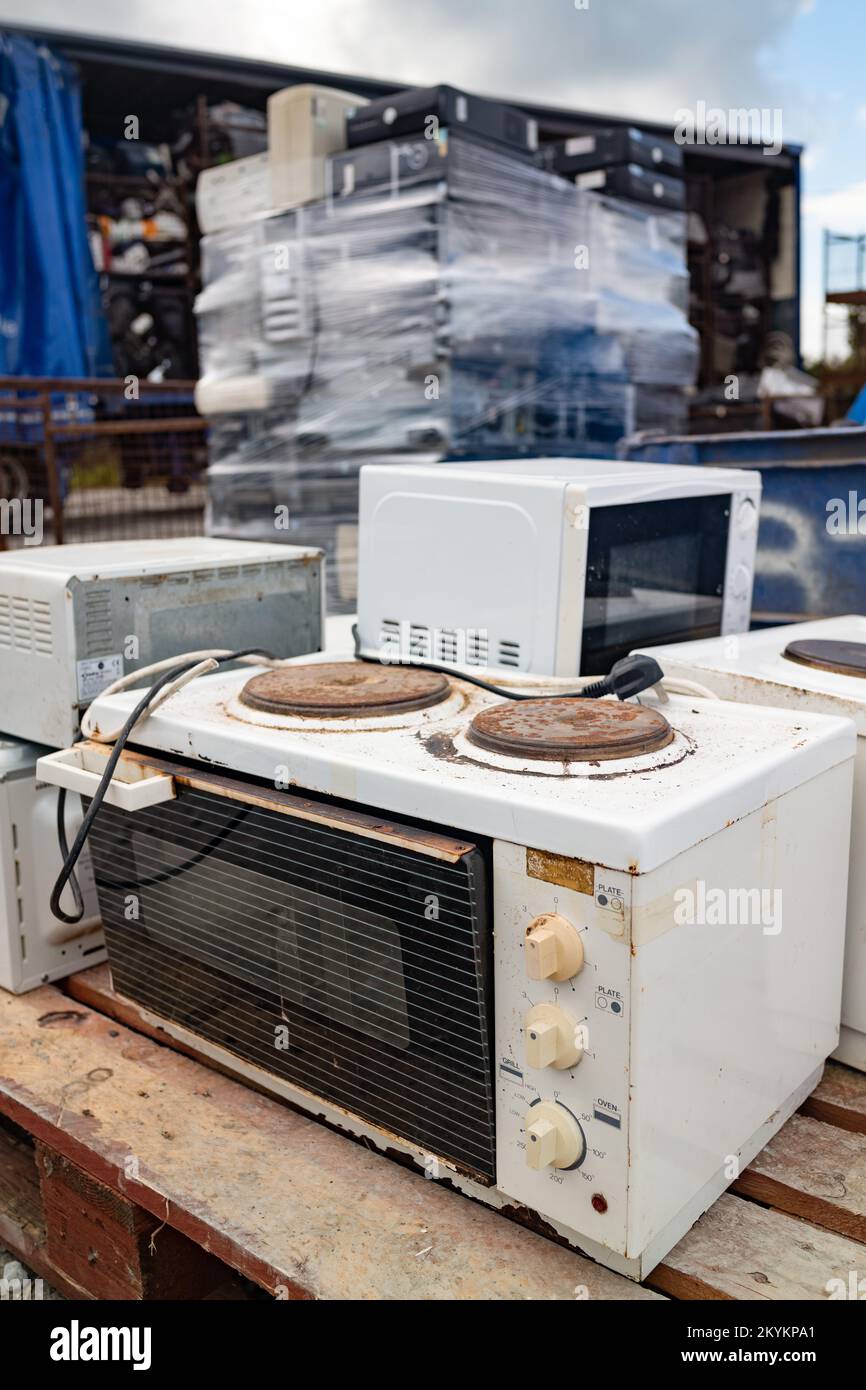 Old broken small hot plate oven and other old e-waste appliances pilled ...