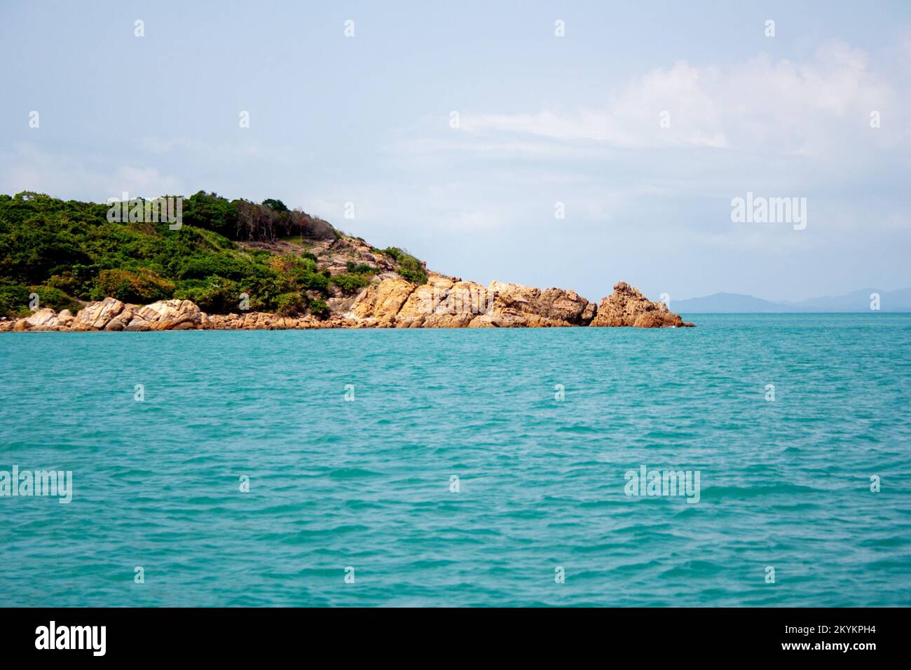 Tropical island with trees and rocky cliff in turquoise color sea Stock ...