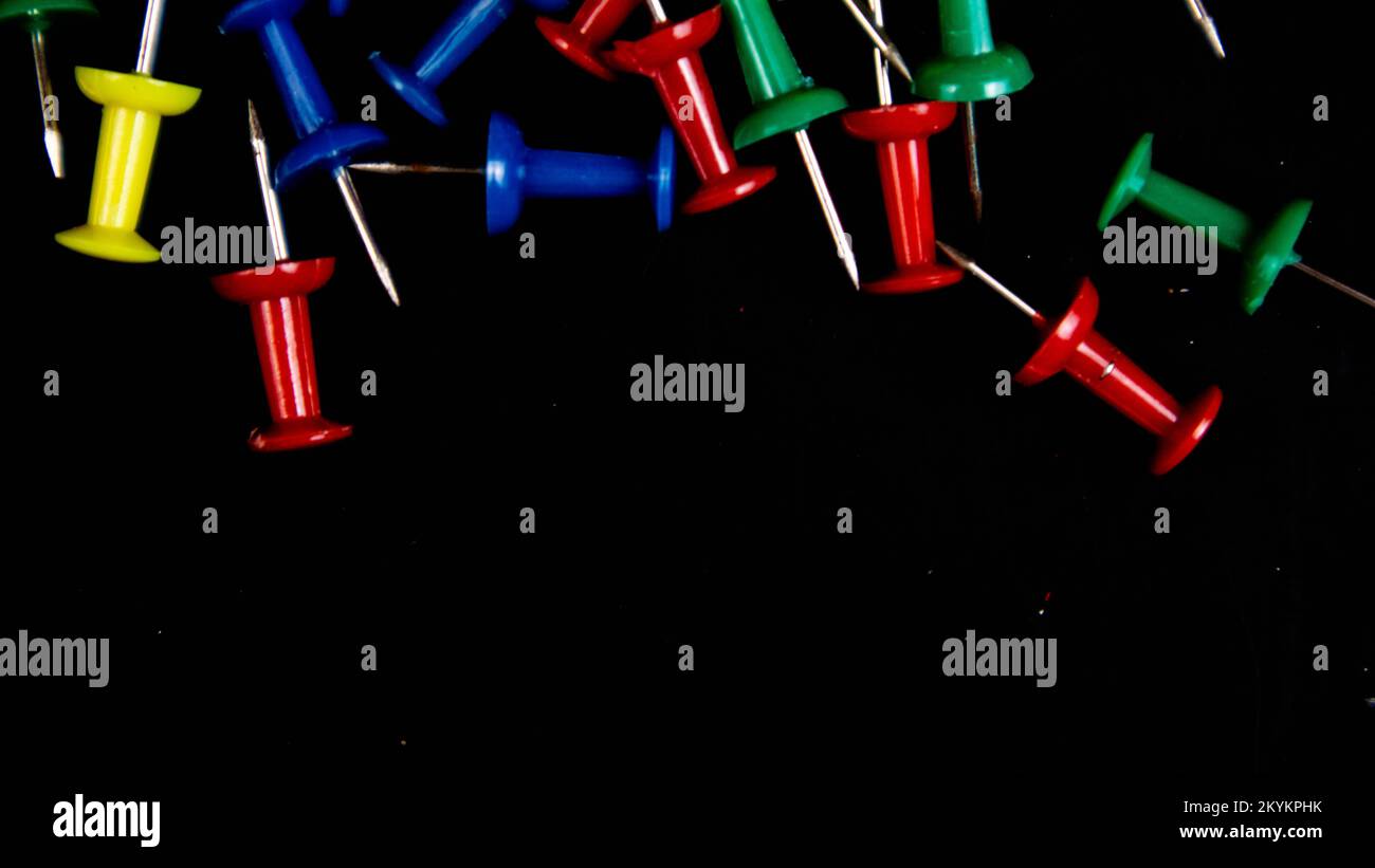 colorful thumbtacks on black background Stock Photo - Alamy