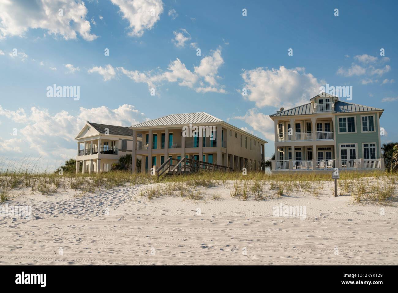 Destin, Florida- Three beach houses facade with wooden footbridge over the sand dunes at the ...