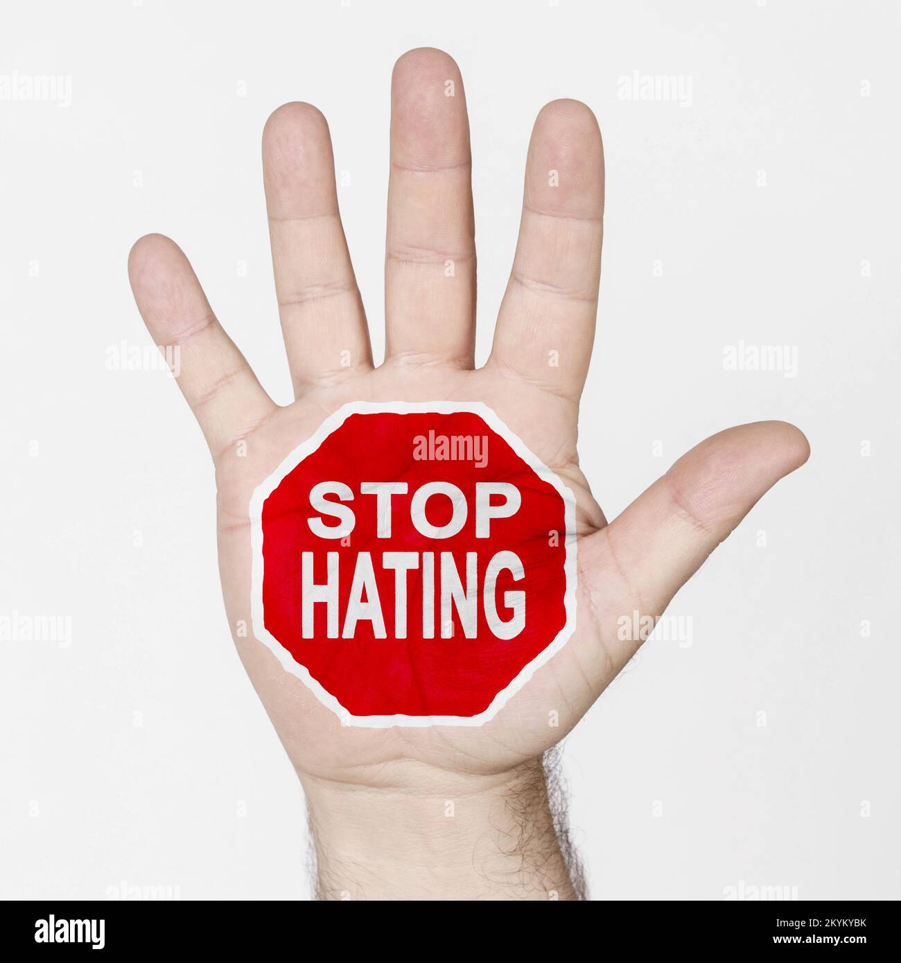 On the palm of the hand there is a stop sign with the inscription - STOP HATING. Isolated on ...
