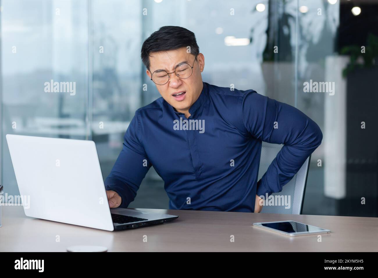 Sick overworked man at work, businessman has severe back pain, asian ...