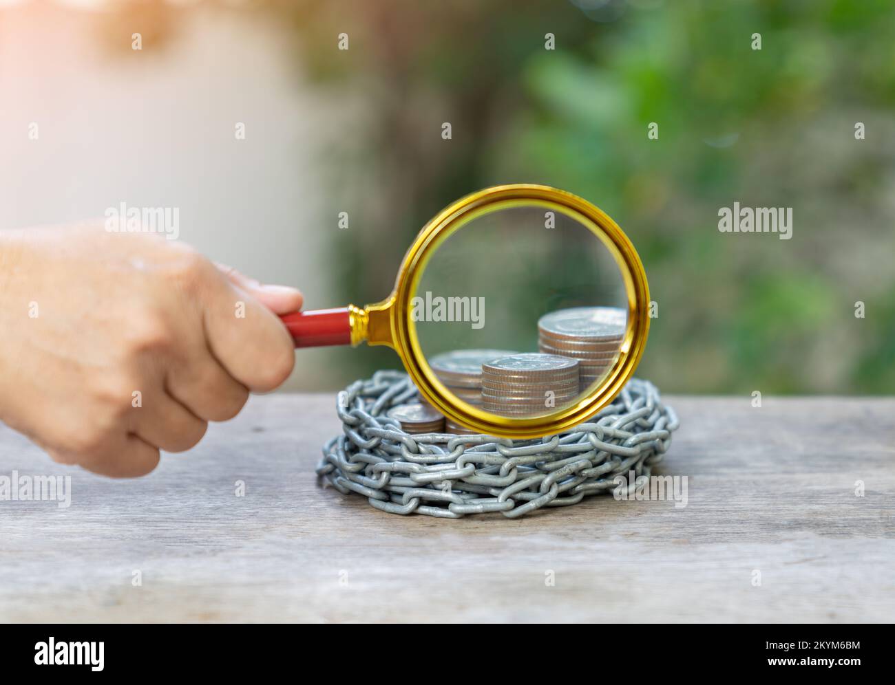 Magnify focus money coin stack in metal chain nest on blur background ...