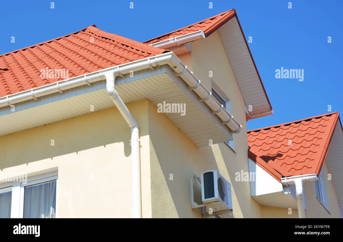 Close up on house metal rooftop with plastic rain gutter pipeline ...