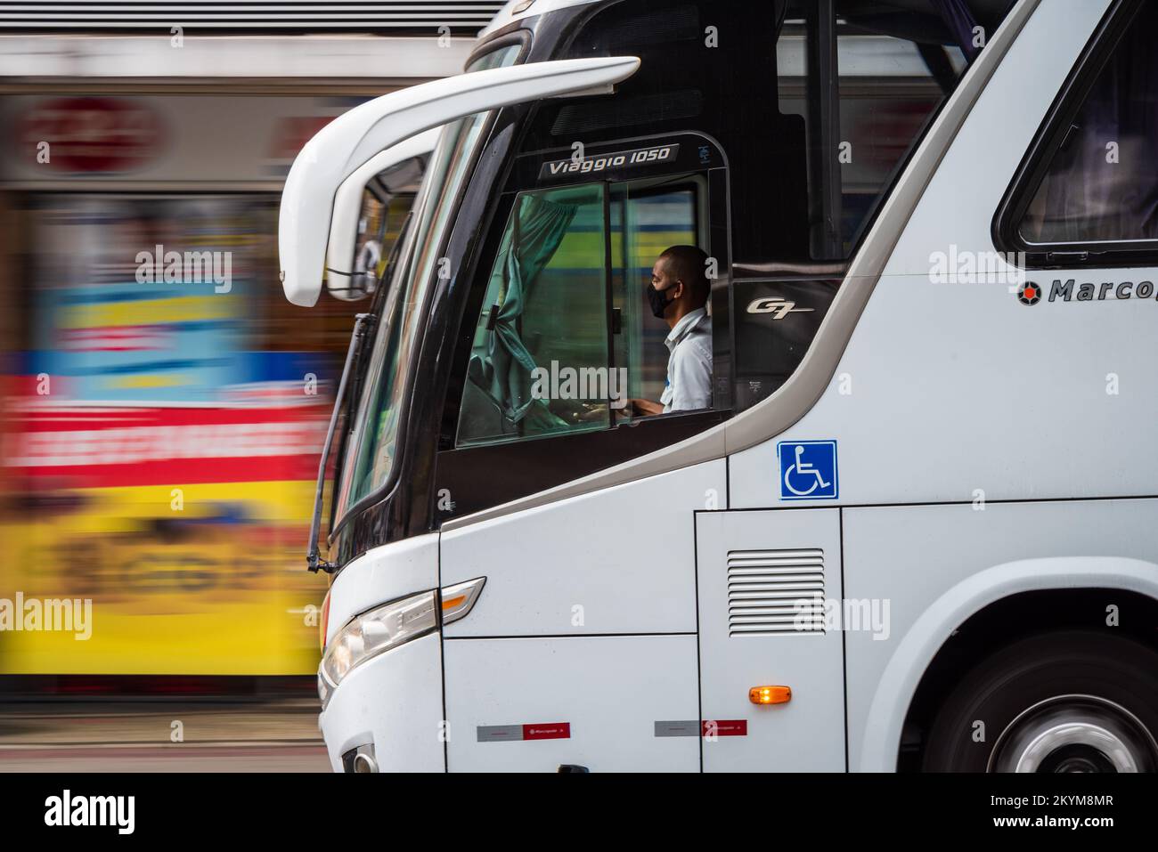 Male Brazilian bus driver driving a white bus in downtown Belo ...