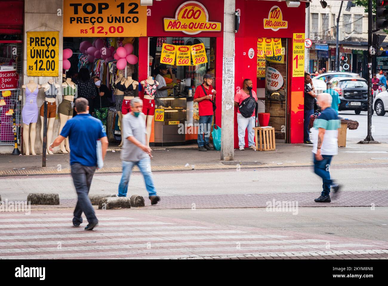 Pedestrians crossing a street with people walking on sidewalk in front ...