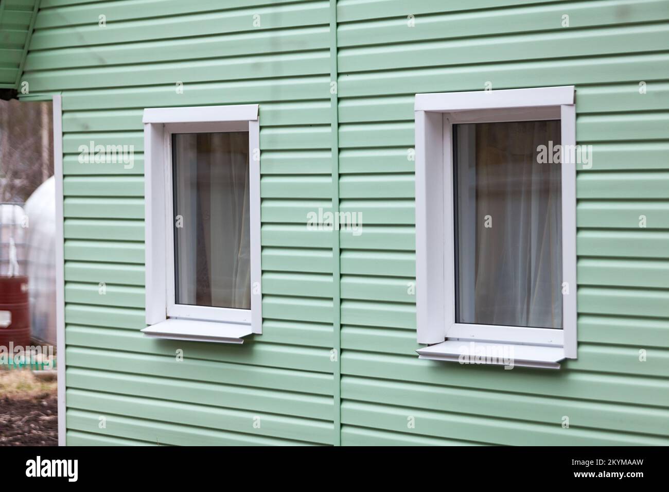 Two plastic windows on the facade of the house. siding finish Stock ...