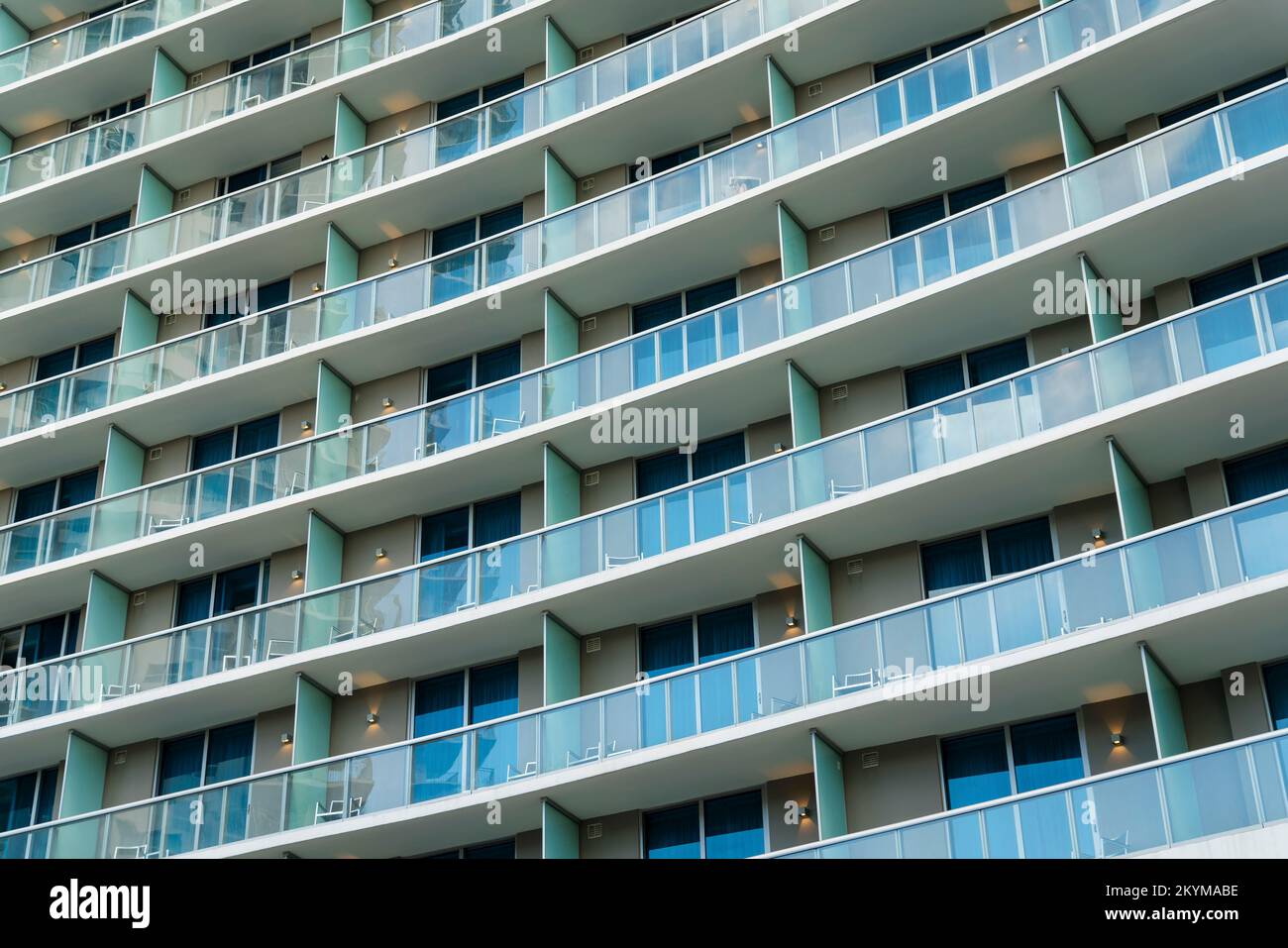 Close-up exterior of a condominium at Miami, FL with glass balcony ...